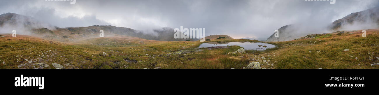 Small Tarn with Fog in Mountains at Sunset Stock Photo - Alamy
