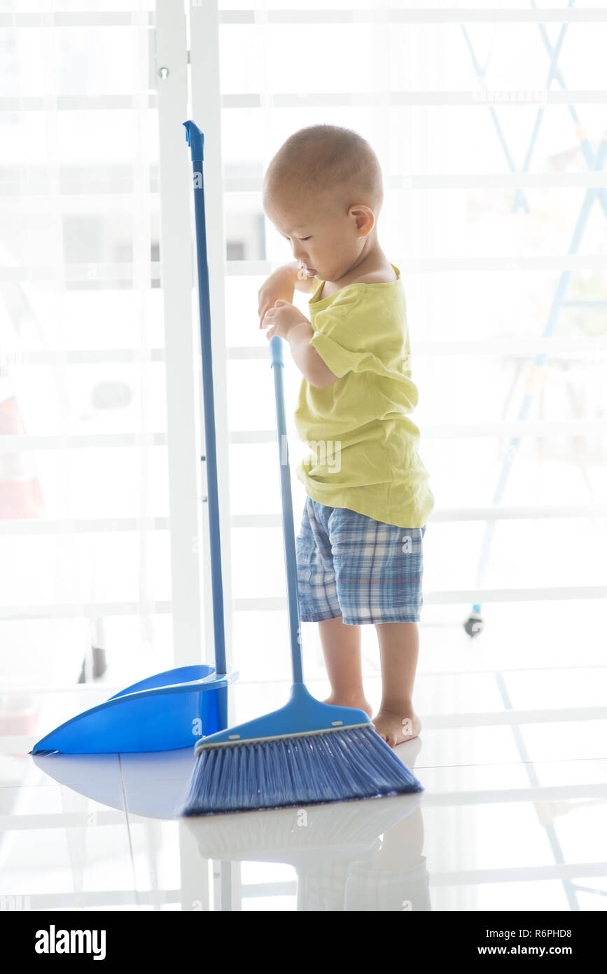 Young kid sweeping floor Stock Photo - Alamy