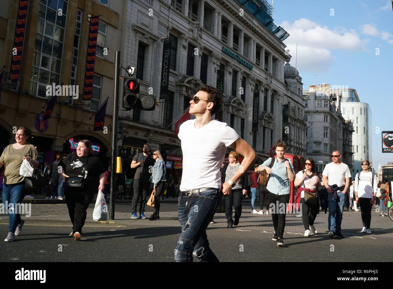 A man crosses a busy road in Piccadilly Circus, London Stock Photo - Alamy