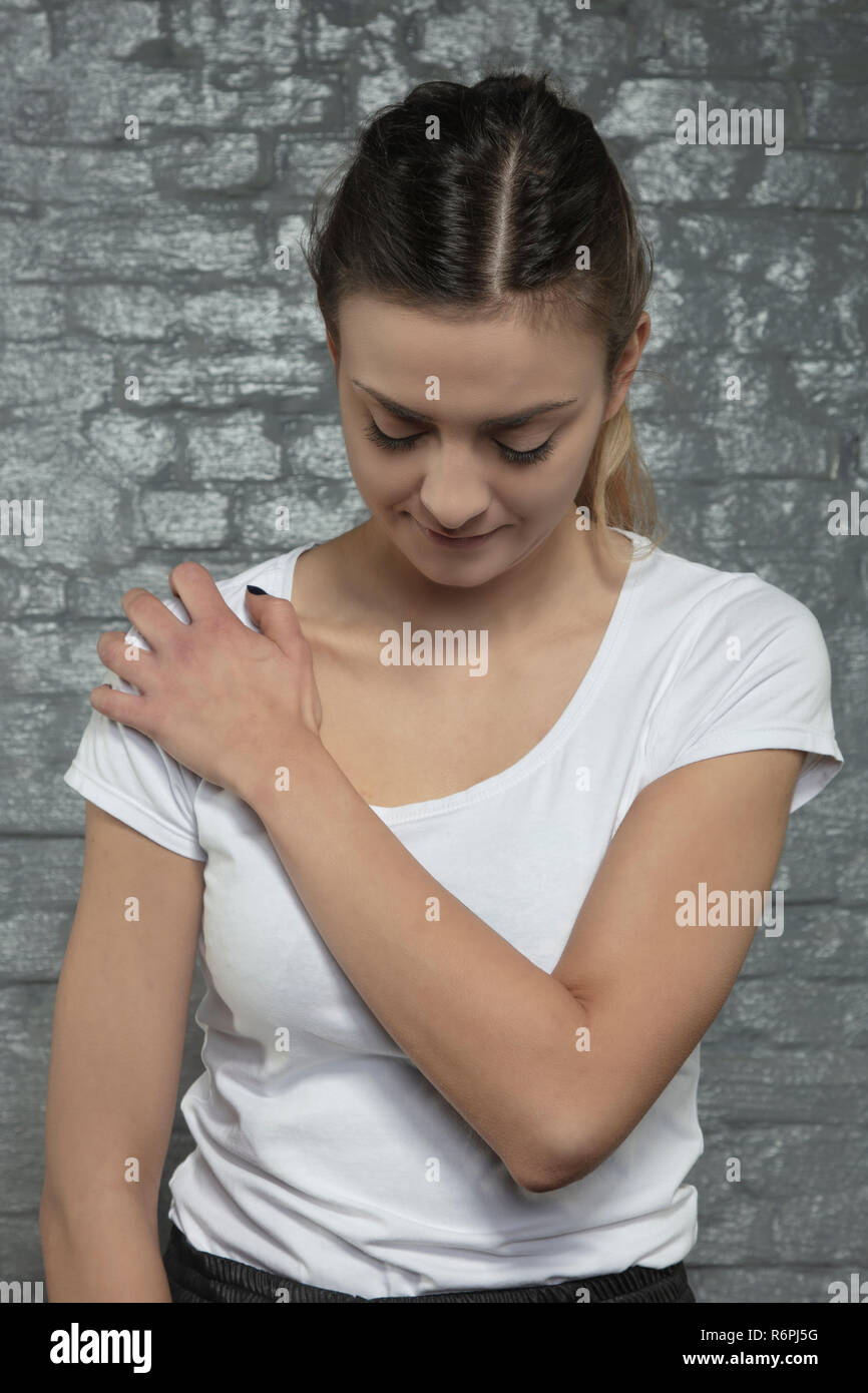 woman is struggling with shoulder pain front view Stock Photo - Alamy