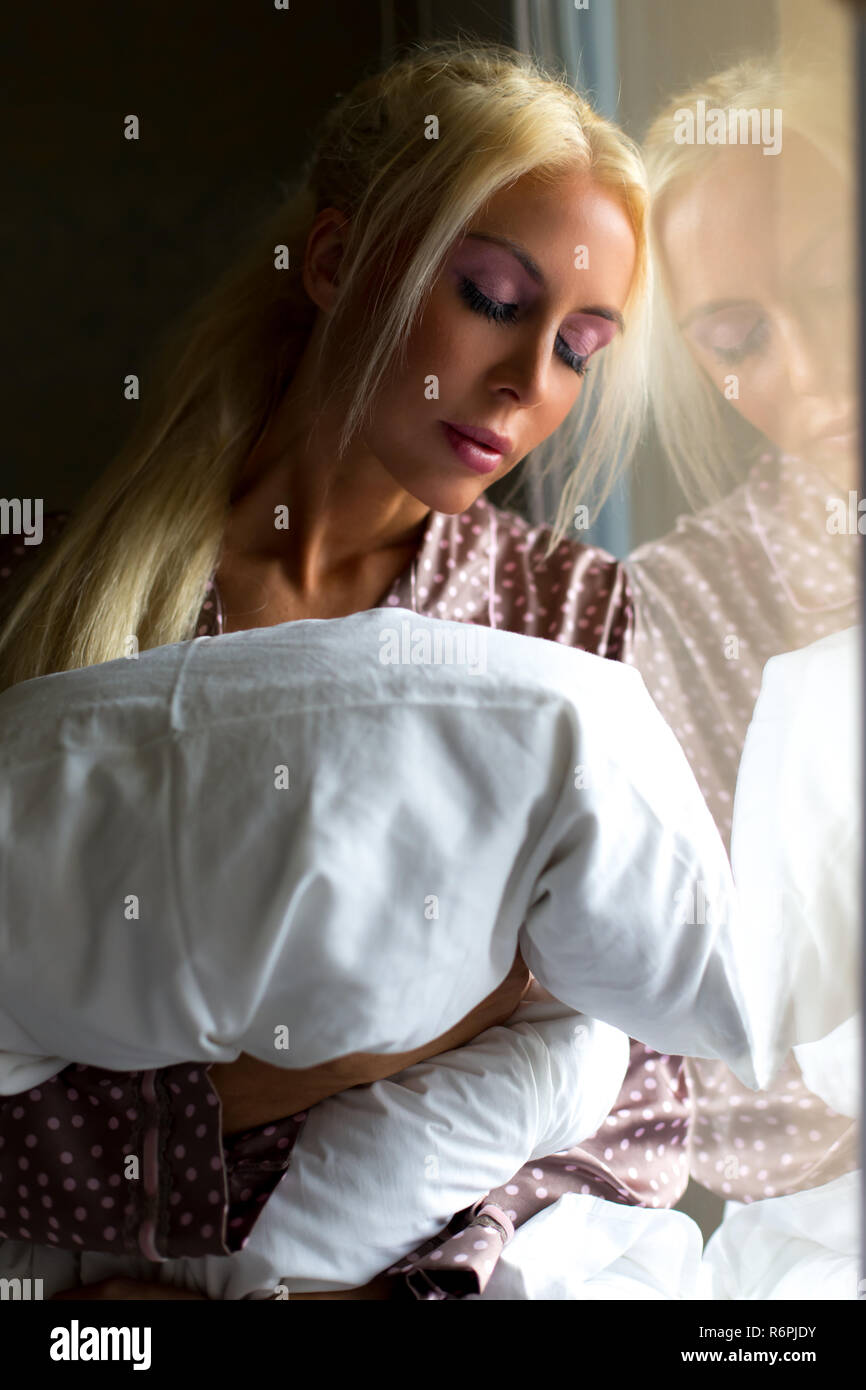 Blonde woman standing at the window Stock Photo - Alamy