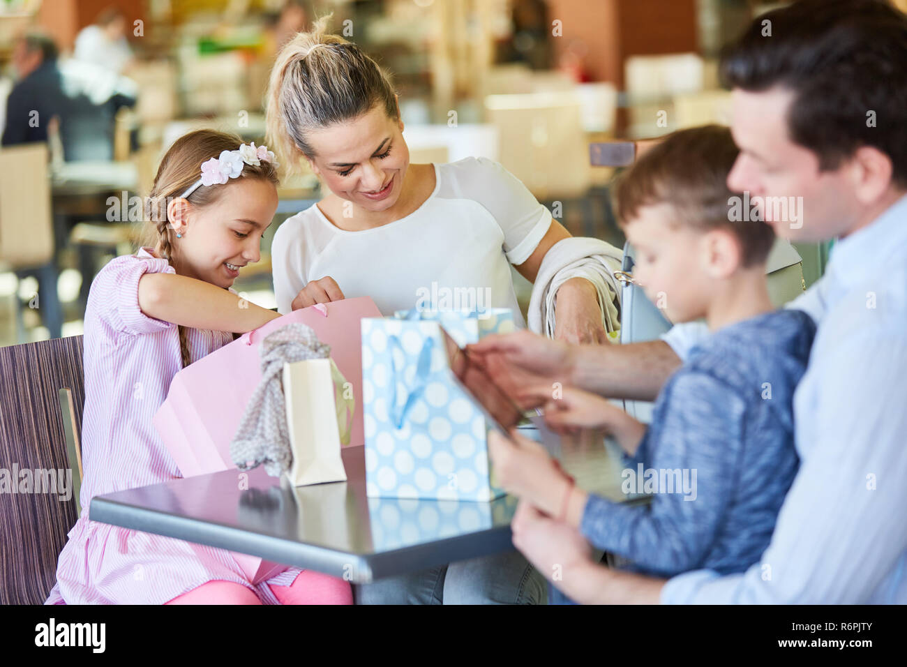 Family with two kids taking a break shopping at the mall Stock Photo ...