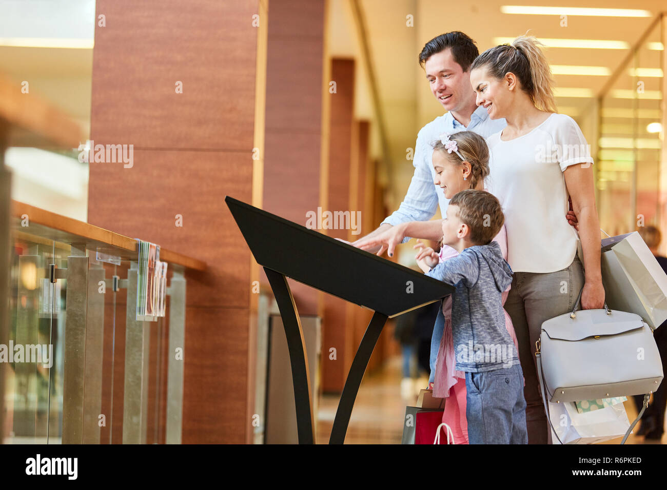 Family at the information kiosk in the mall as an interactive customer ...