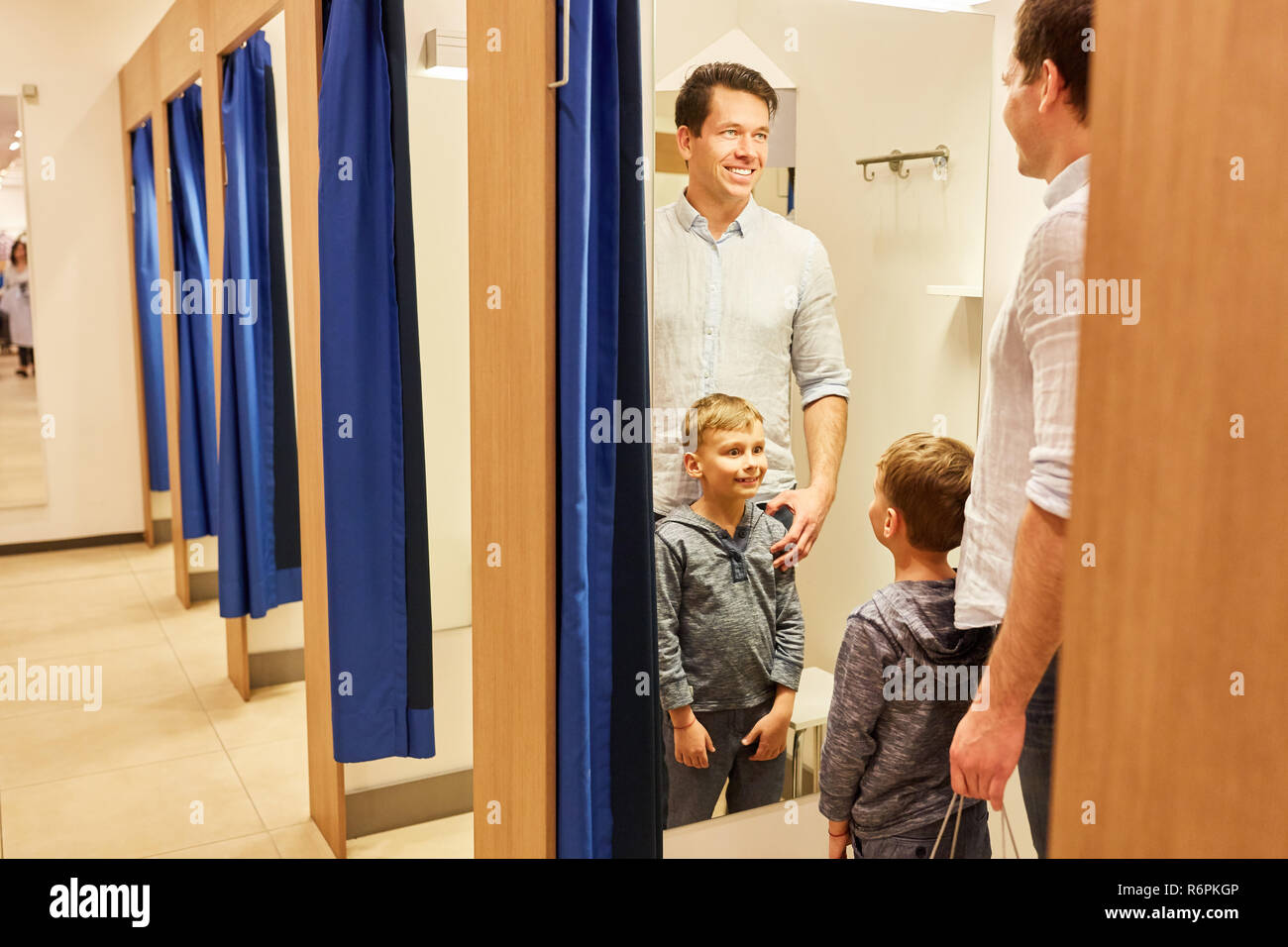 Father and son together in the dressing room of a discount store while ...