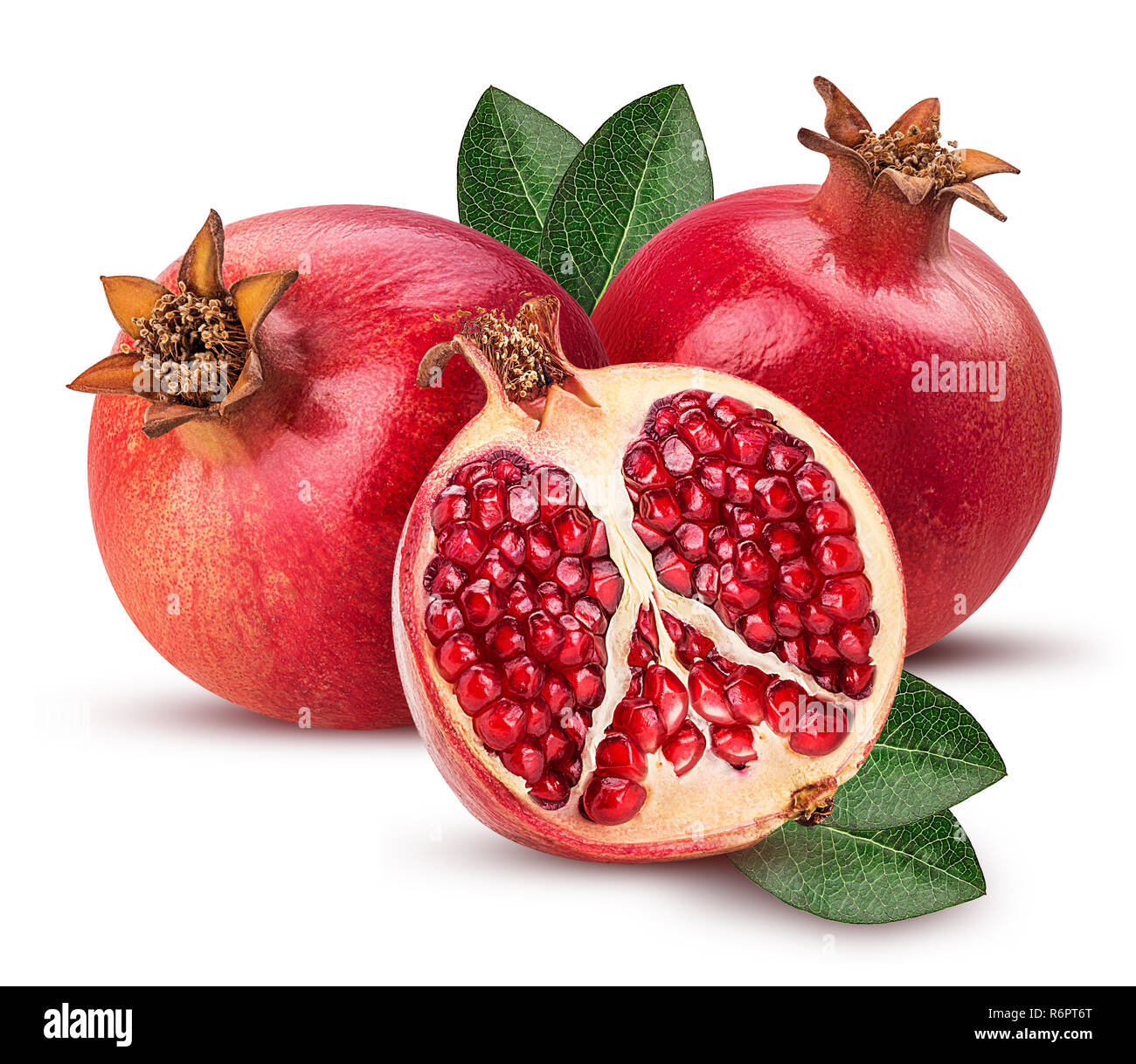 Two pomegranate and one cut in half with leaf isolated on white ...