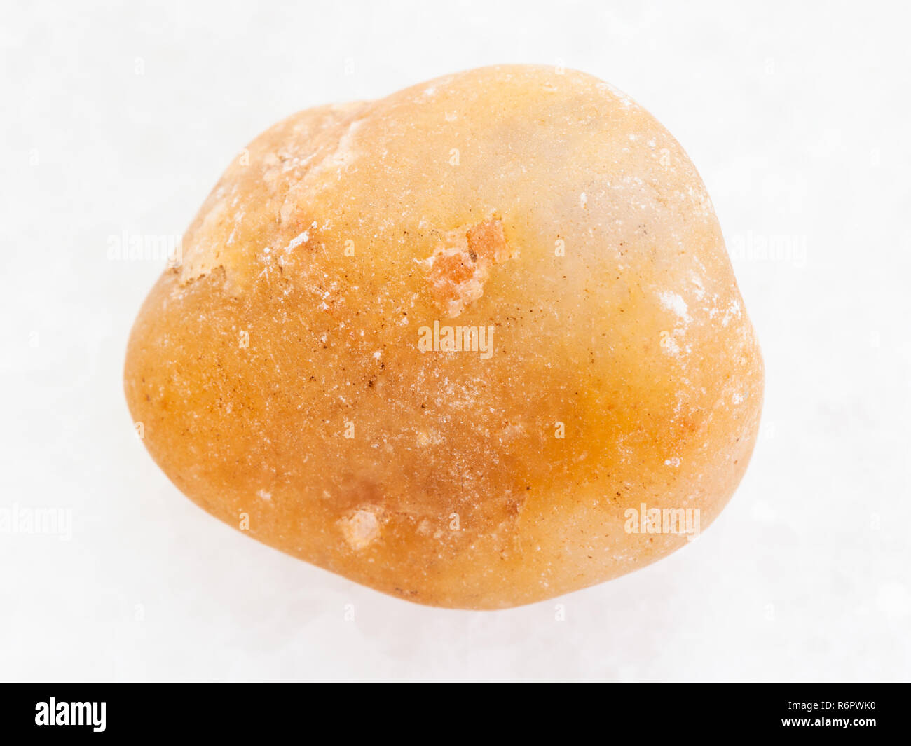 tumbled yellow chalcedony pebble on white Stock Photo - Alamy