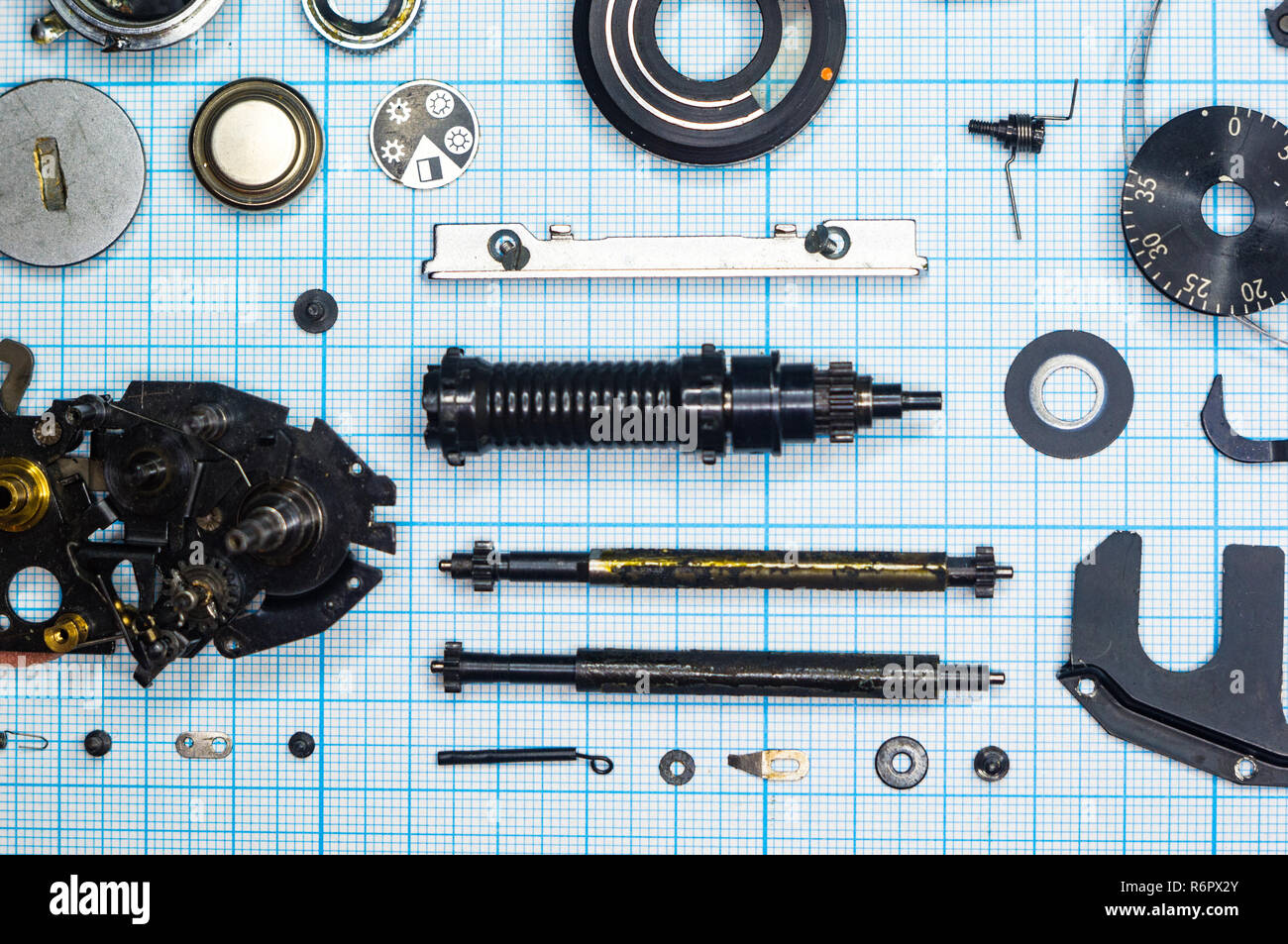 parts are completely disassembled old retro film SLR camera on graph ...