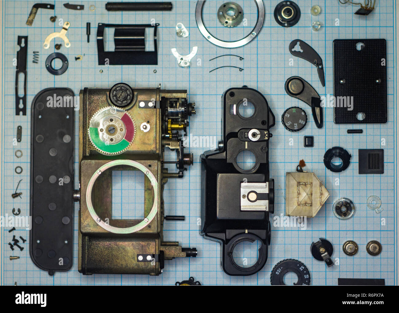 parts are completely disassembled old retro film SLR camera on graph ...