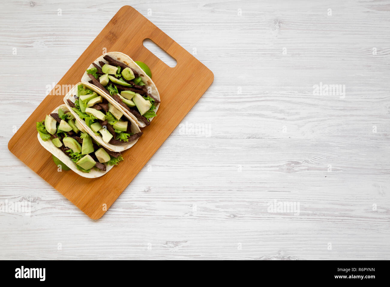 Mexican tacos on the bamboo board on a white wooden background ...