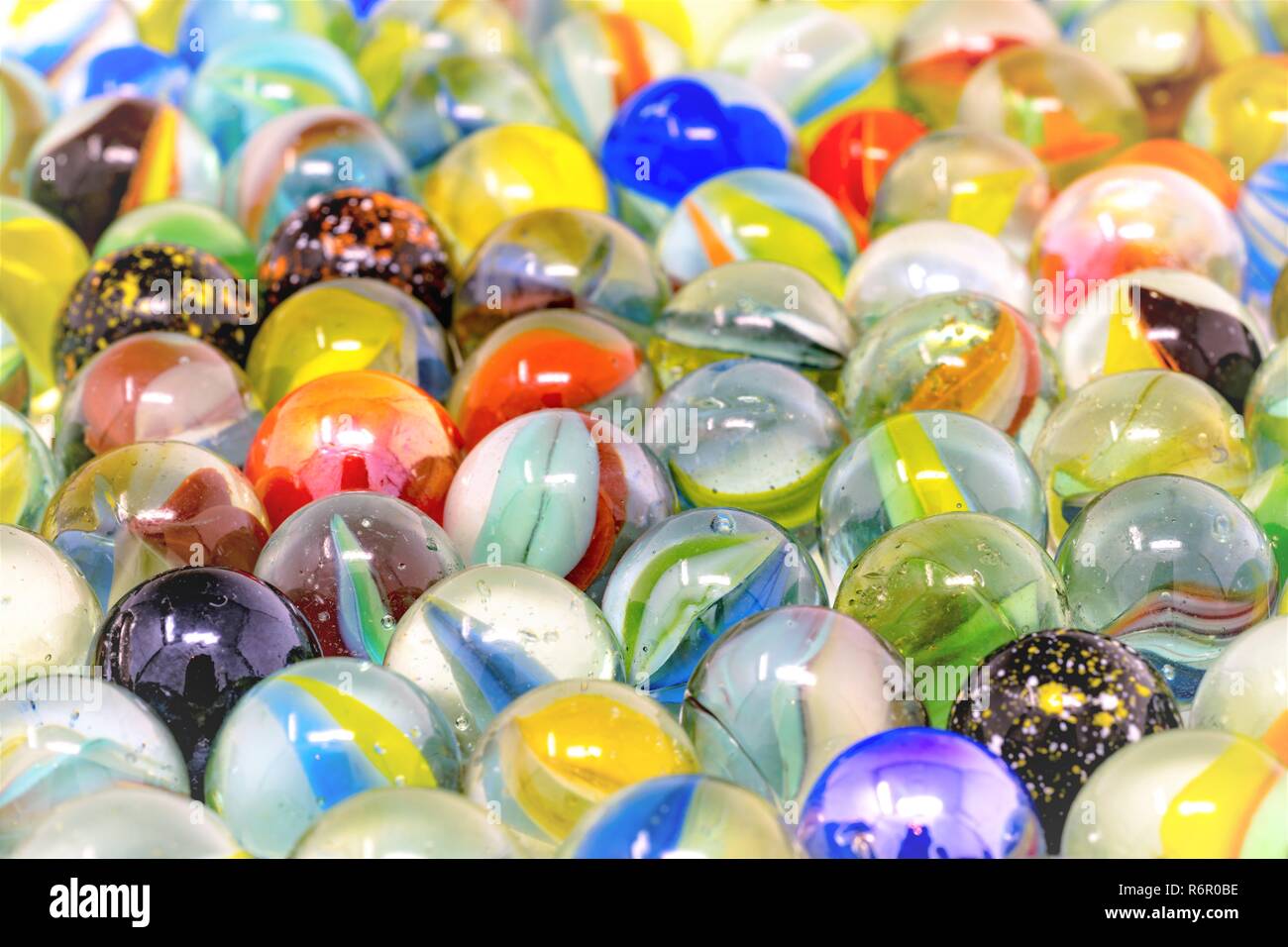 many colorful glass marbles full frame with blurred areas as background ...