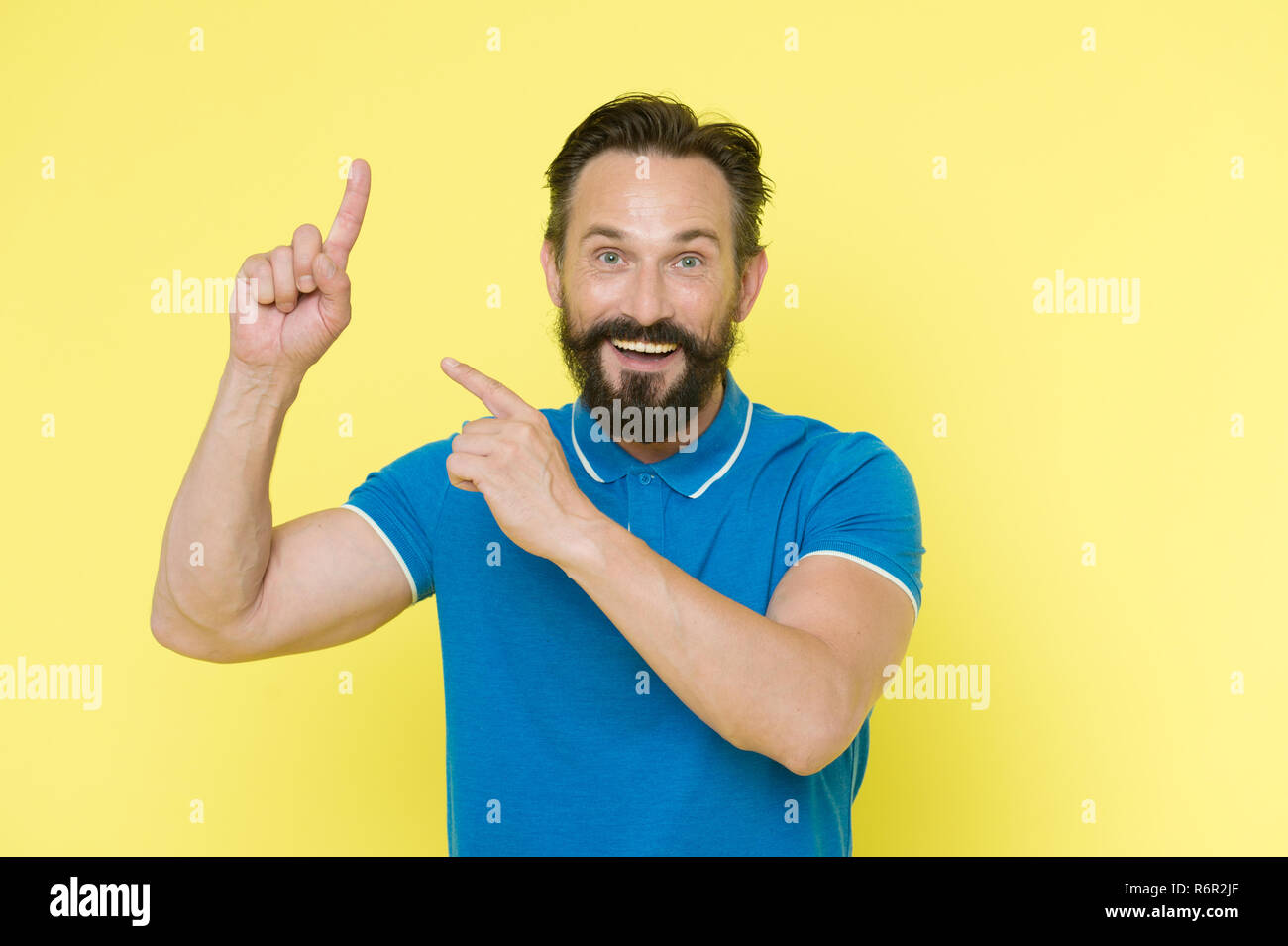 Pointing direction. Man pointing index fingers yellow background. Guy ...