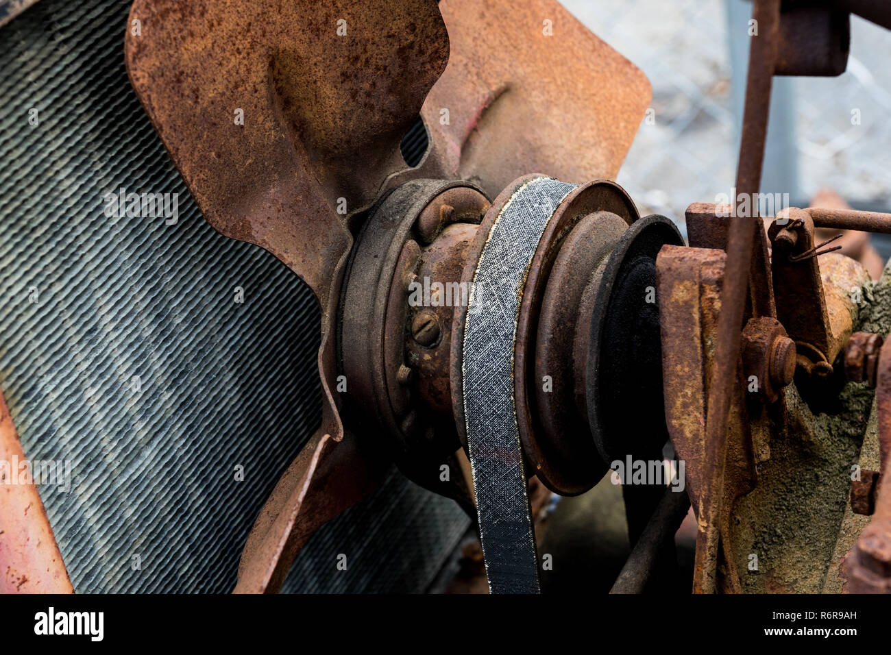 Vintage antique automotive tractor rusty fan blade and belt behind the ...