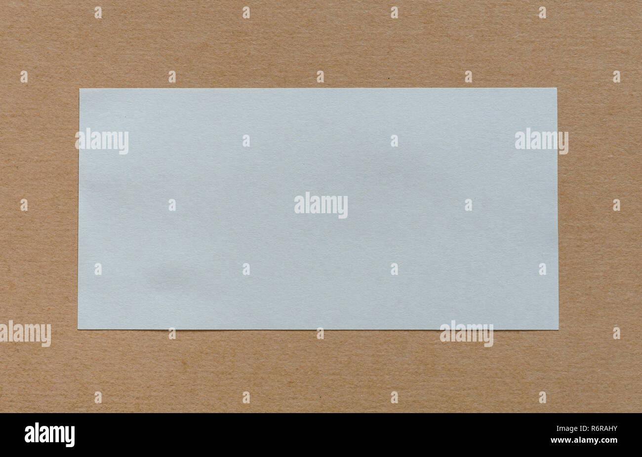 Blank white paper label on brown cardboad background Stock Photo - Alamy