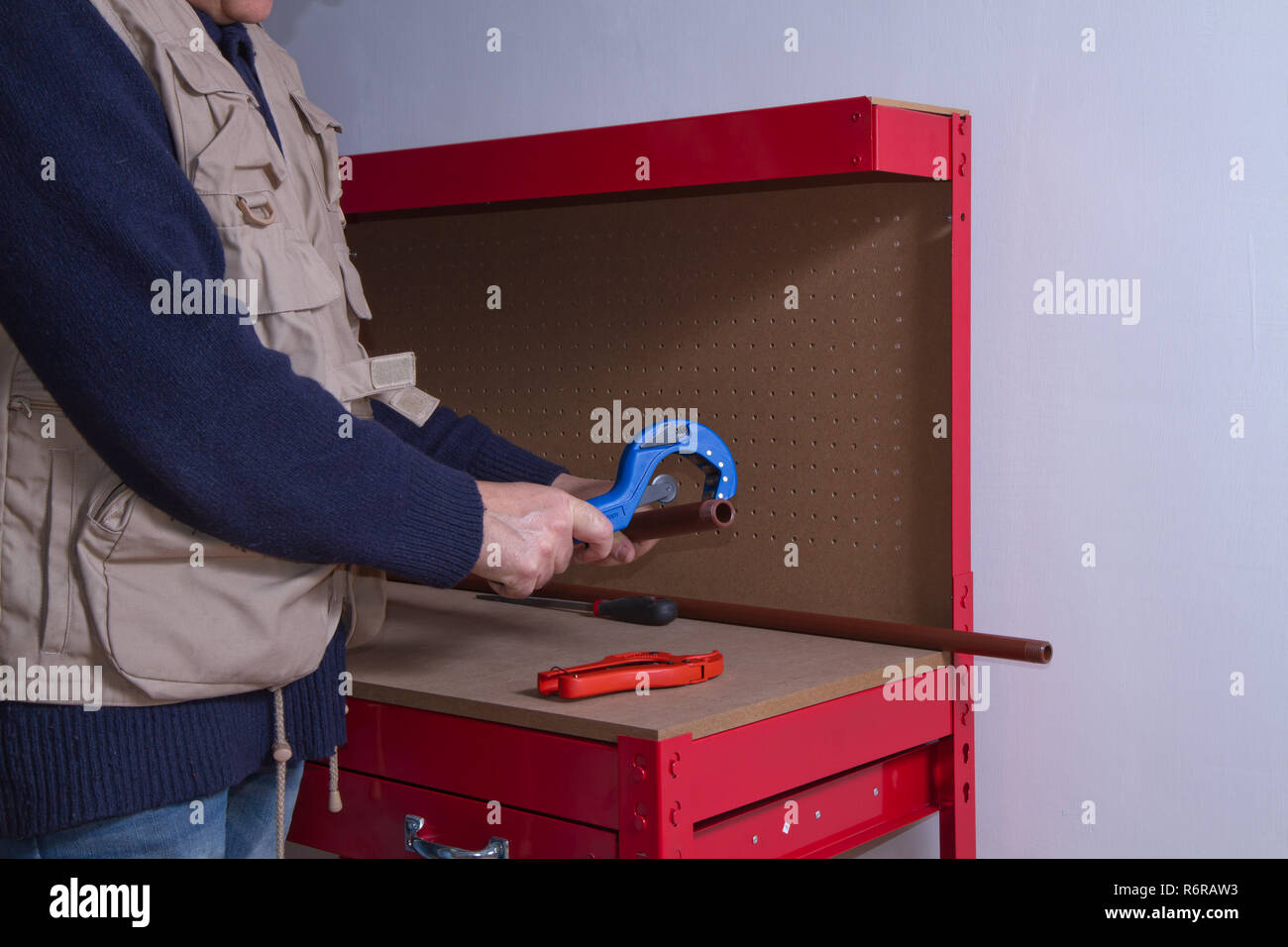 plumber at work on his workbench to fit pipes Stock Photo - Alamy