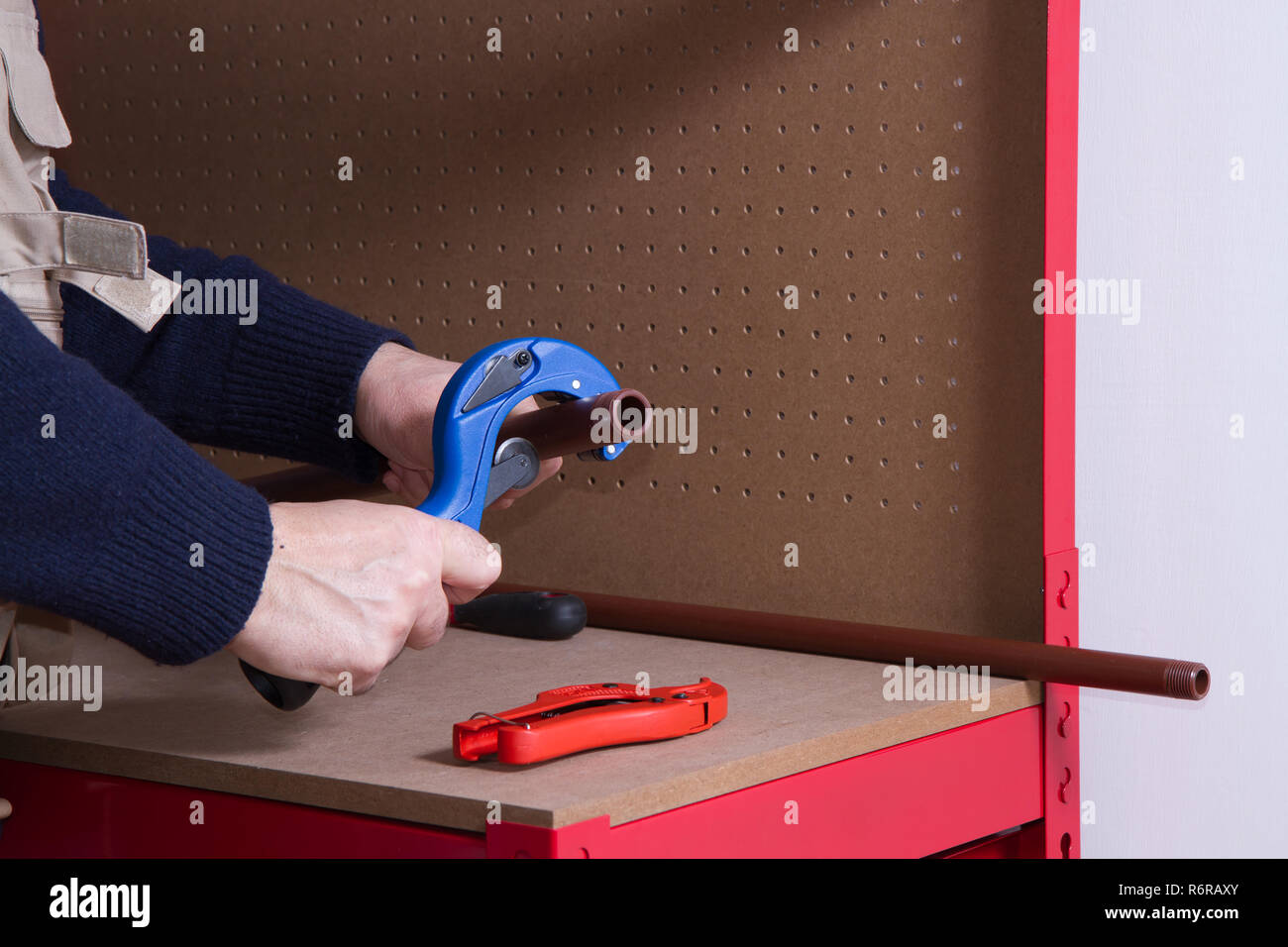 plumber at work on his workbench to fit pipes Stock Photo - Alamy