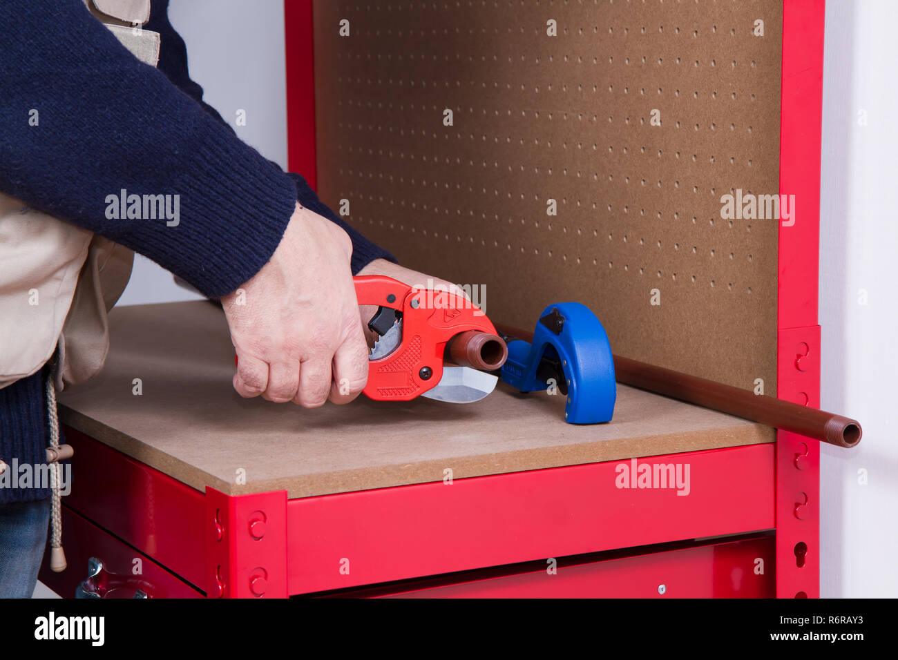 plumber at work on his workbench to fit pipes Stock Photo - Alamy