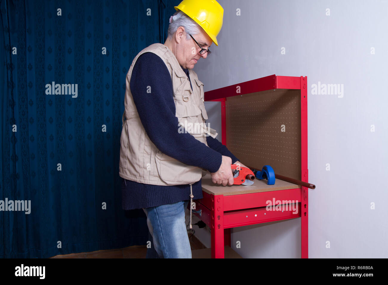 plumber at work on his workbench to fit pipes Stock Photo - Alamy