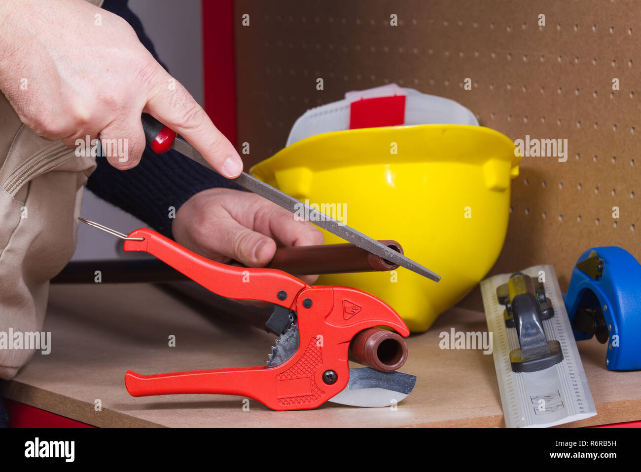 plumber at work on his workbench to fit pipes Stock Photo - Alamy