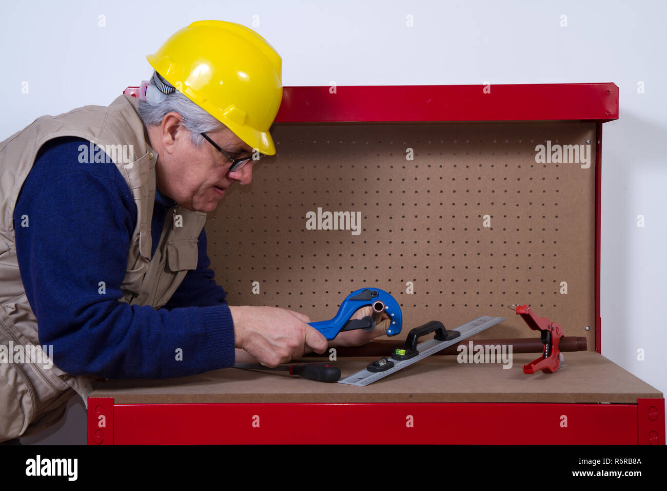 plumber at work on his workbench to fit pipes Stock Photo - Alamy