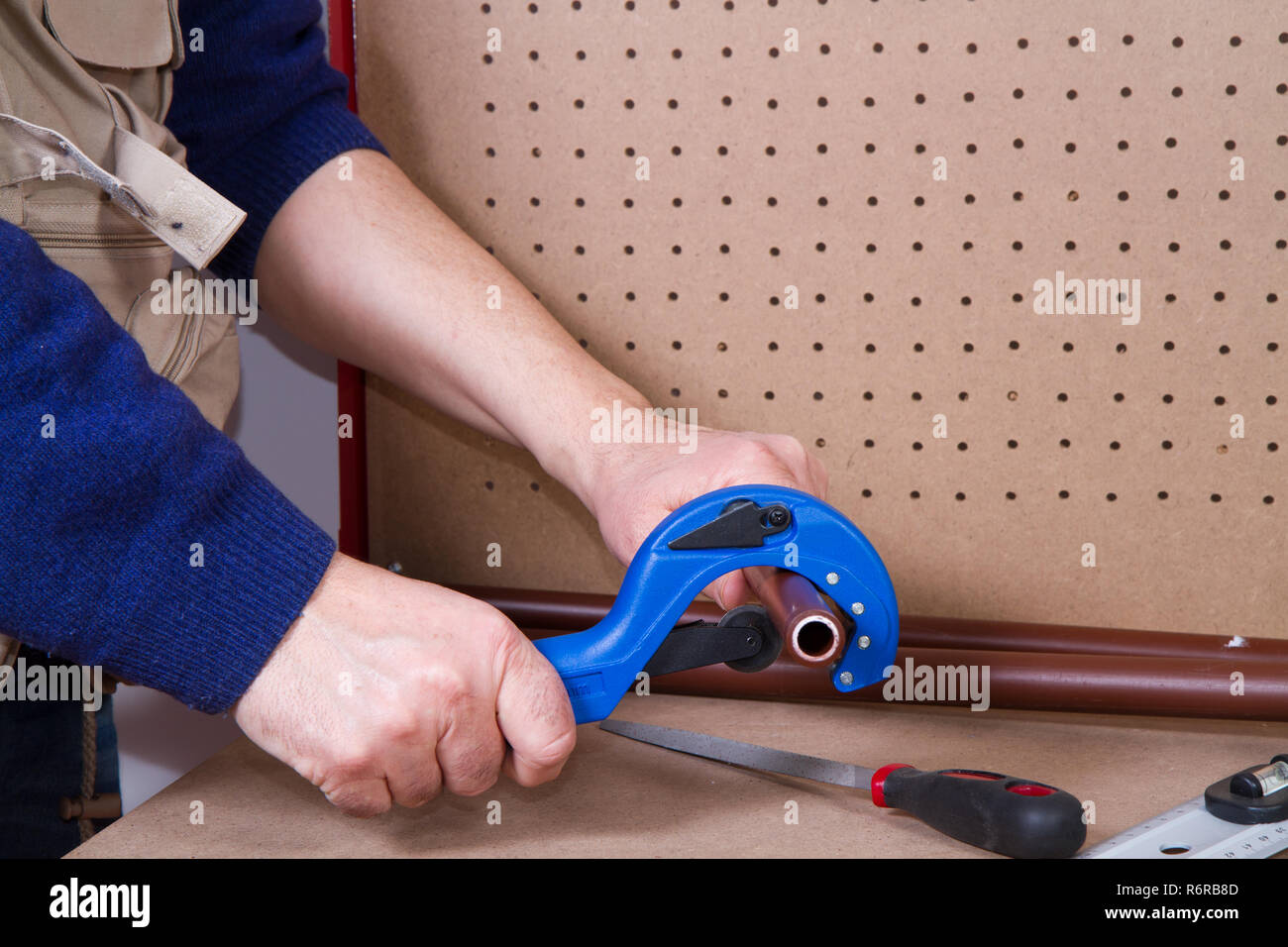 plumber at work on his workbench to fit pipes Stock Photo - Alamy