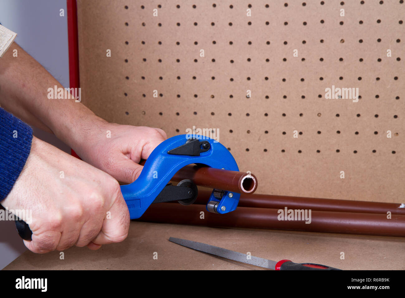 plumber at work on his workbench to fit pipes Stock Photo - Alamy