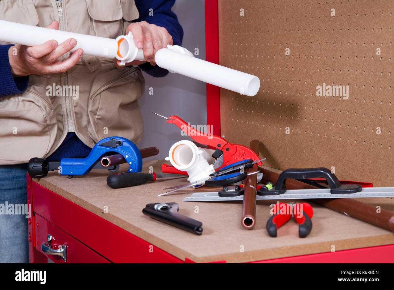 plumber at work on his workbench to fit pipes Stock Photo - Alamy