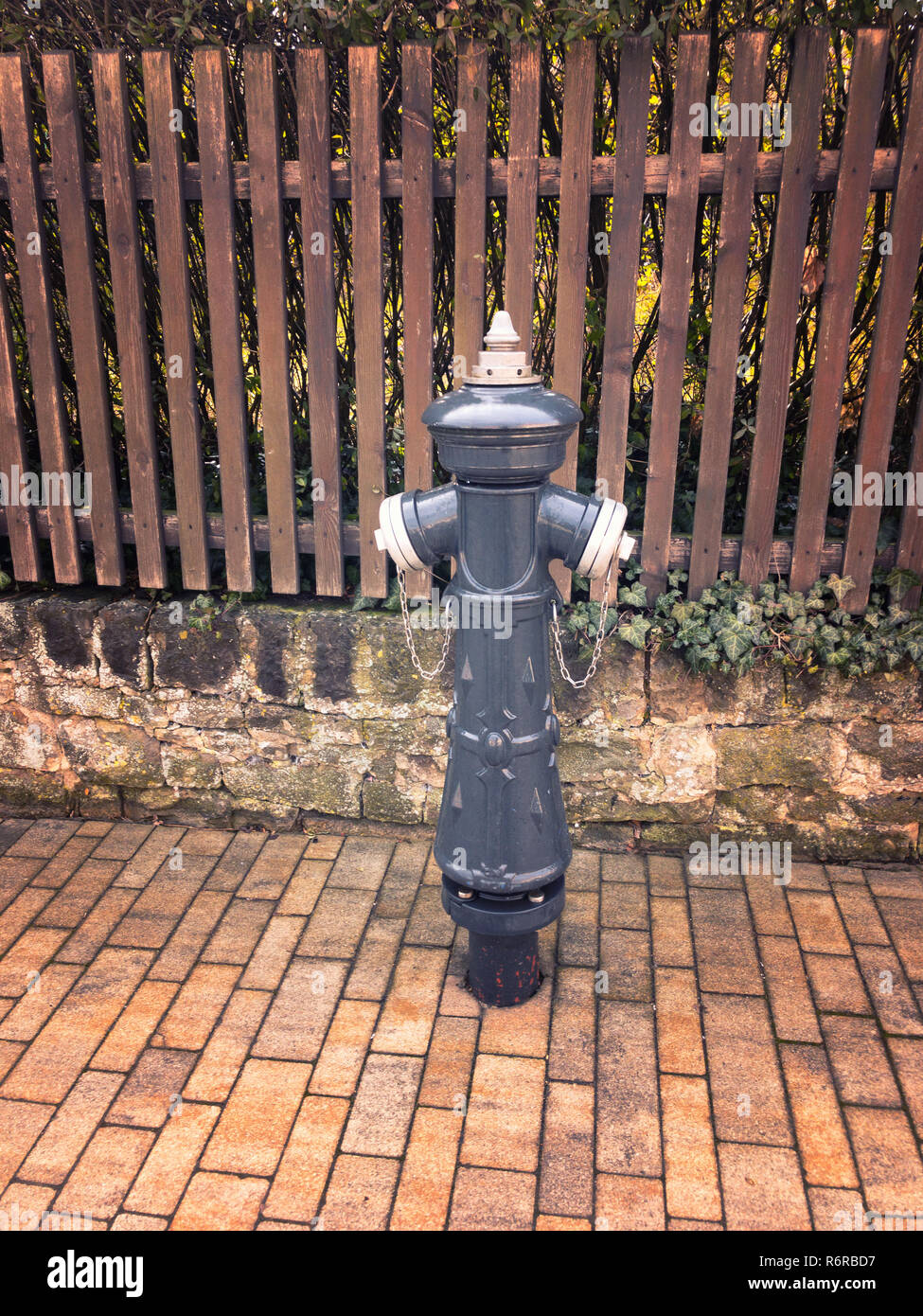 Fire hydrant in front of a wooden fence Stock Photo - Alamy