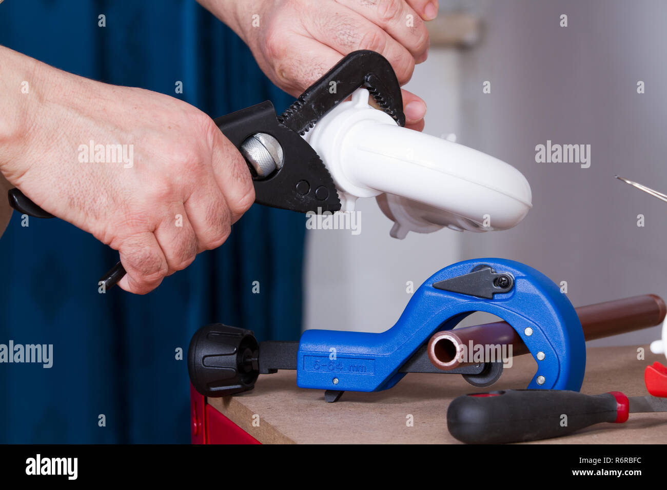 plumber at work on his workbench to fit pipes Stock Photo - Alamy