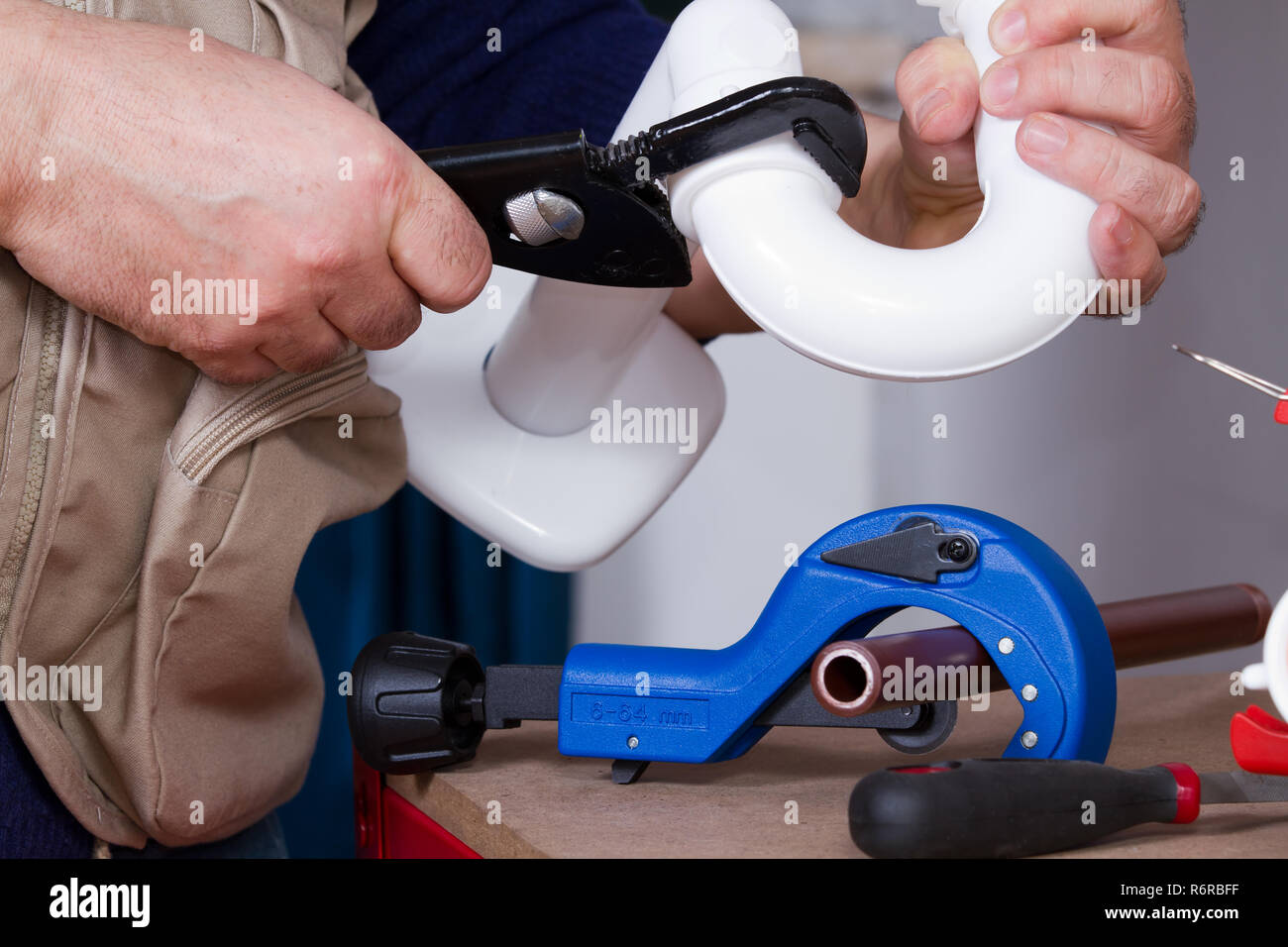 plumber at work on his workbench to fit pipes Stock Photo - Alamy
