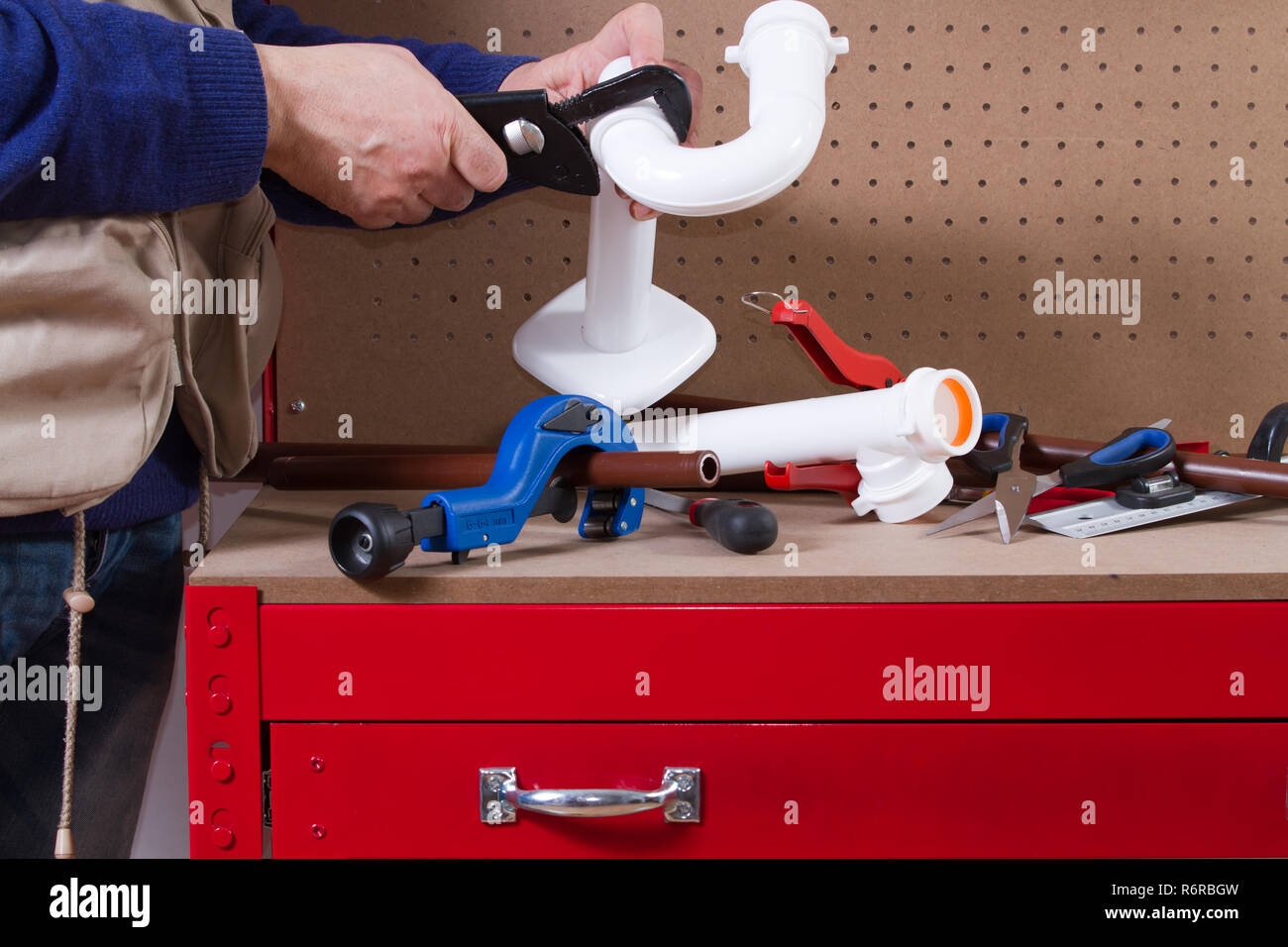 plumber at work on his workbench to fit pipes Stock Photo - Alamy