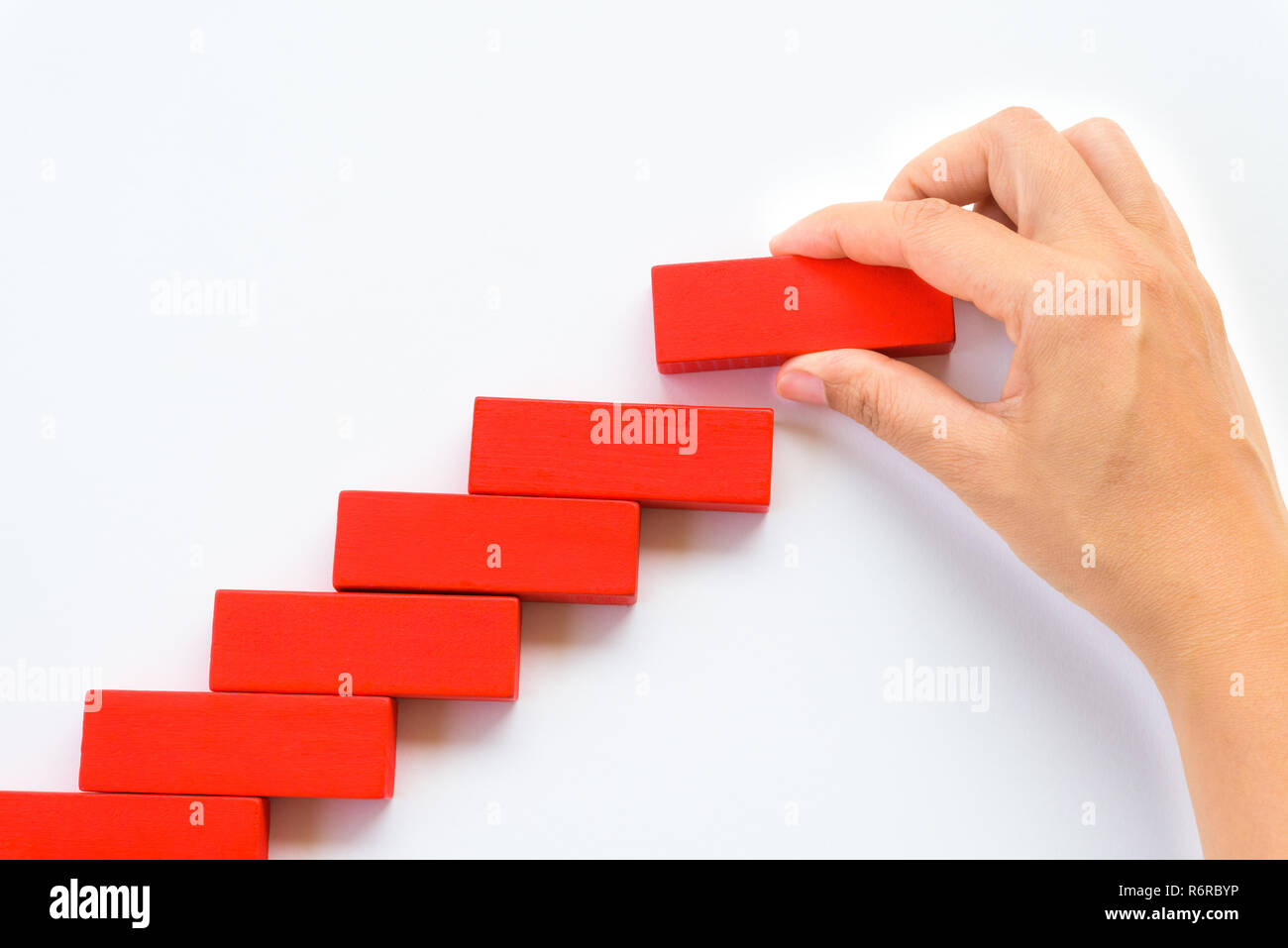 Concept of building success foundation. Women hand put red wooden block ...
