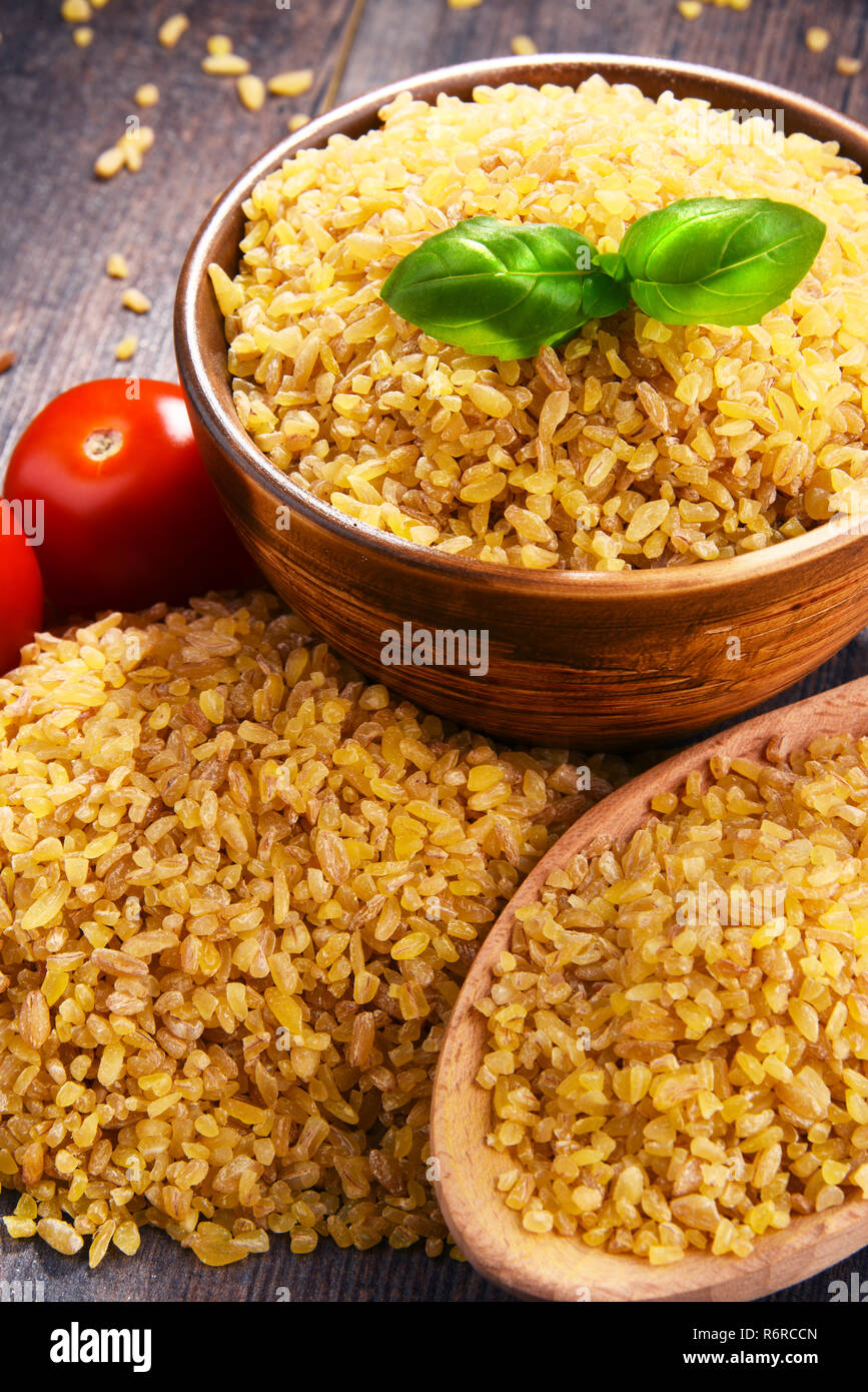Bowl of uncooked bulgur on wooden table Stock Photo - Alamy