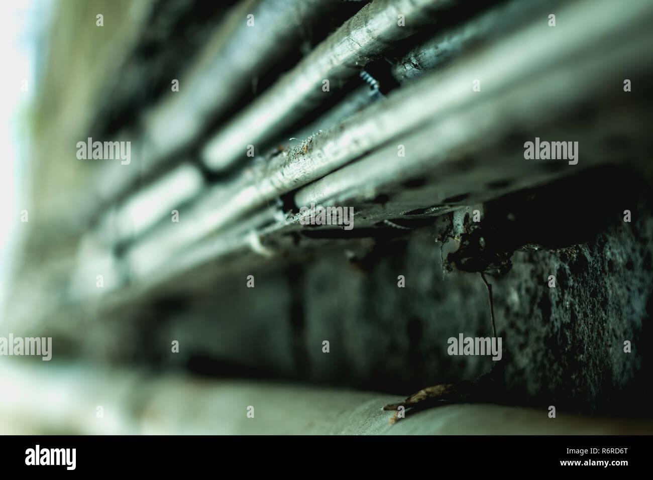 very dirty electrical cables along a concrete wall Stock Photo - Alamy