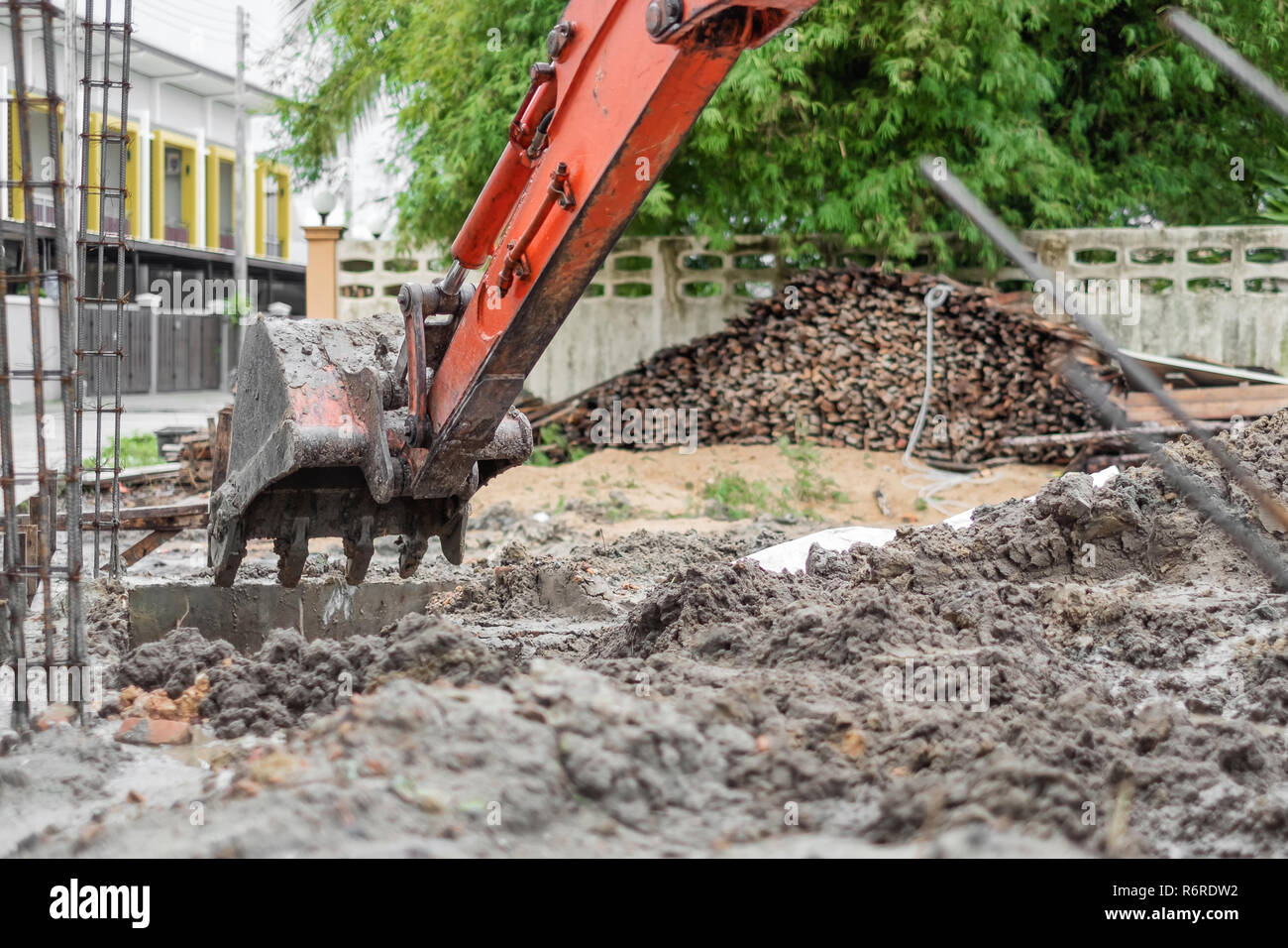 Small backhoe is digging a hole on construction site Stock Photo - Alamy