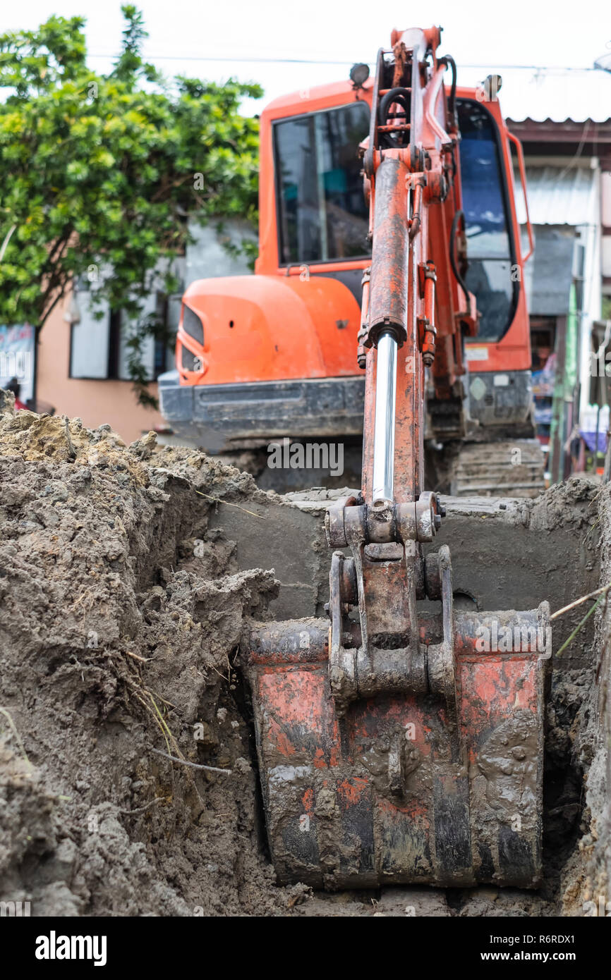 Small backhoe is digging a hole on construction site Stock Photo - Alamy