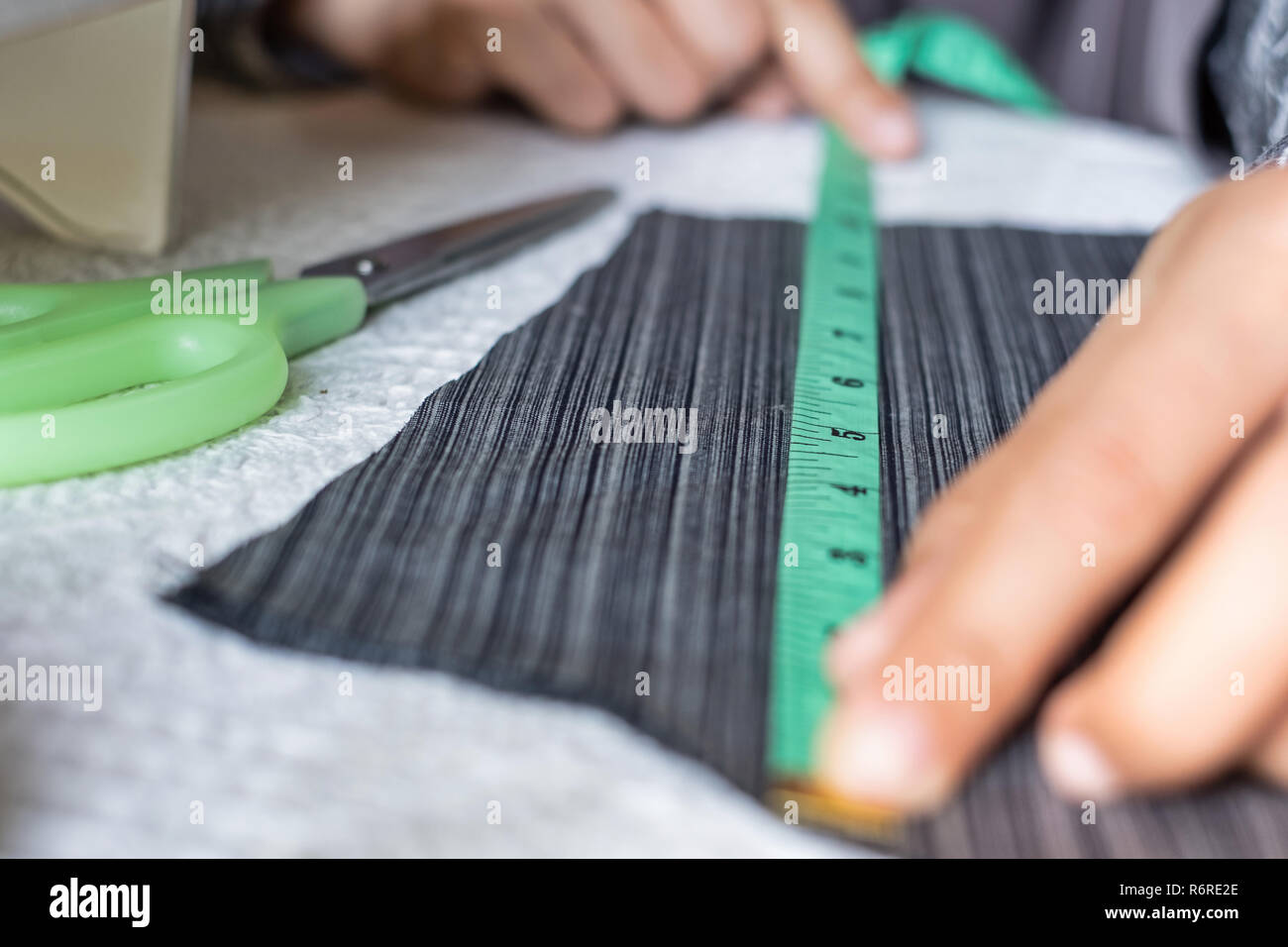 A fashion designer measuring the fabric to create a dress, fashion ...