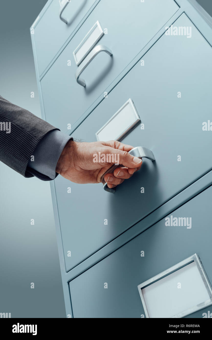 Office clerk searching files in the filing cabinet Stock Photo - Alamy