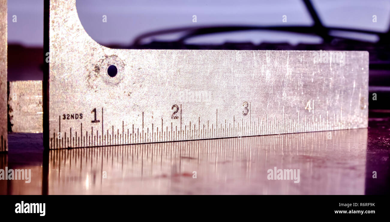 Metal measuring ruler on reflective brown surface Stock Photo - Alamy