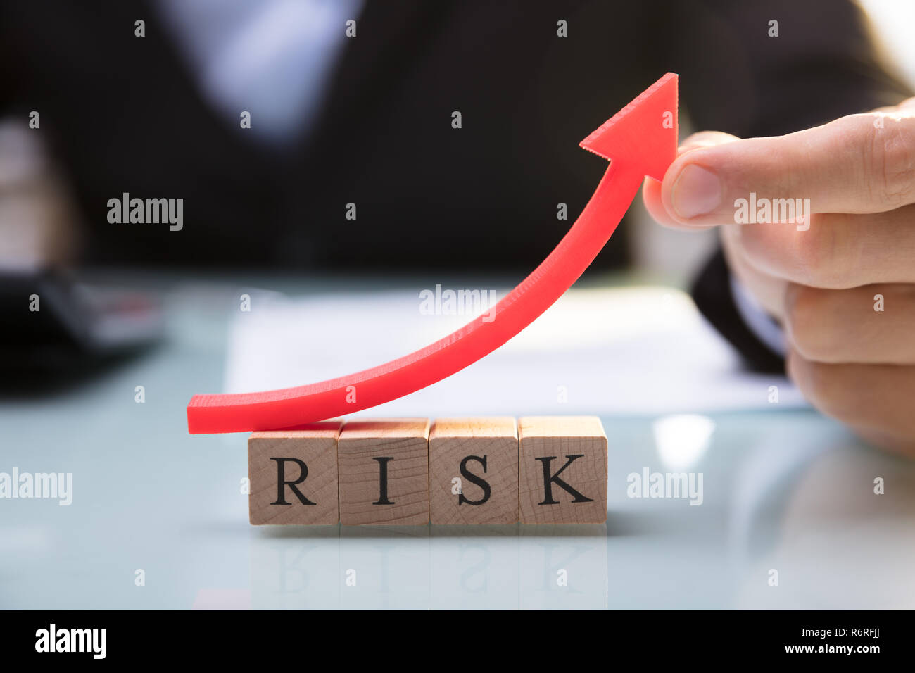 Businessperson Holding Red Arrow Over Risk Blocks Stock Photo - Alamy