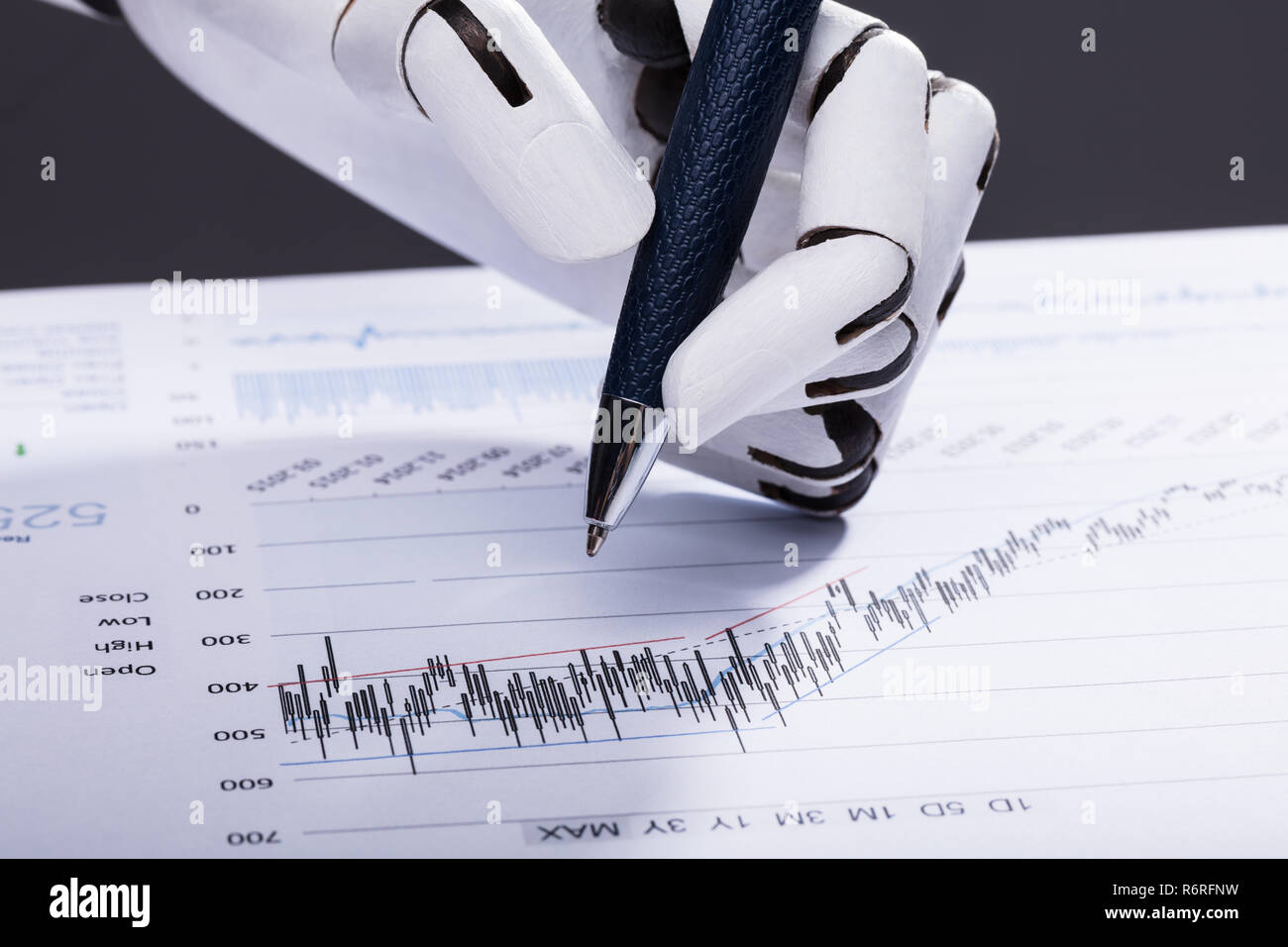 Robot Holding Pen Over Financial Document Stock Photo - Alamy