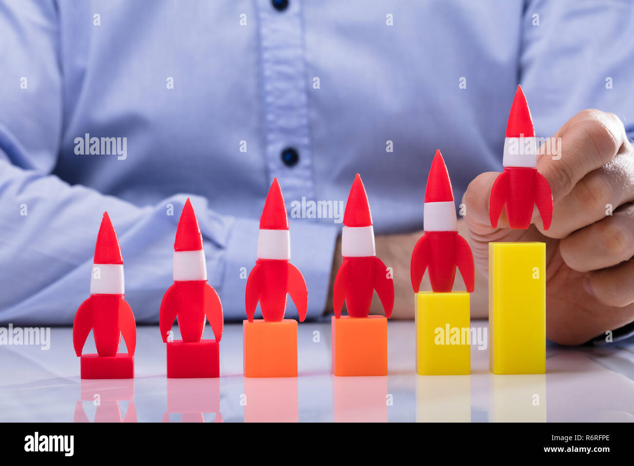 Person Placing Rocket On Top Of Increasing Graph Stock Photo - Alamy