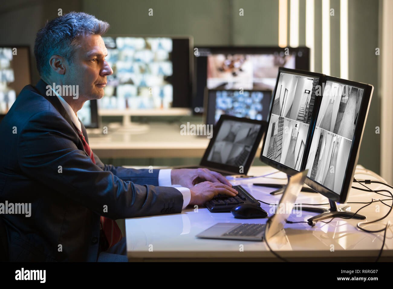Businessman Looking At CCTV Camera Footage Stock Photo - Alamy