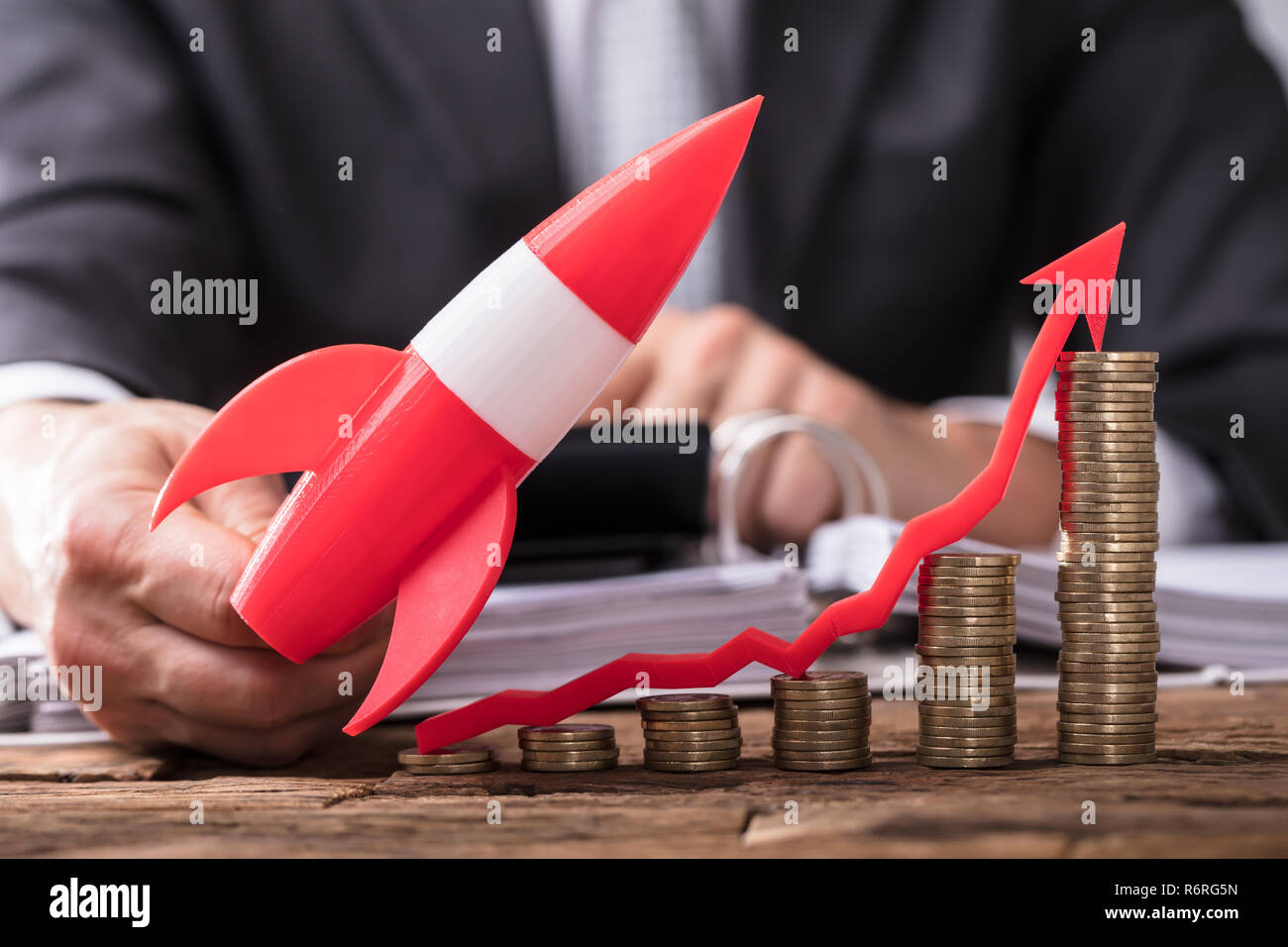 Businessperson Flying Rocket Over Coins Showing Upward Direction Stock ...