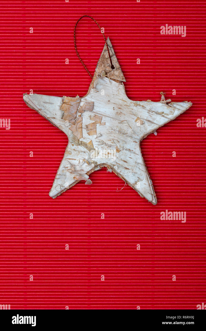 Beautiful star of birch bark on red corrugated cardboard background ...