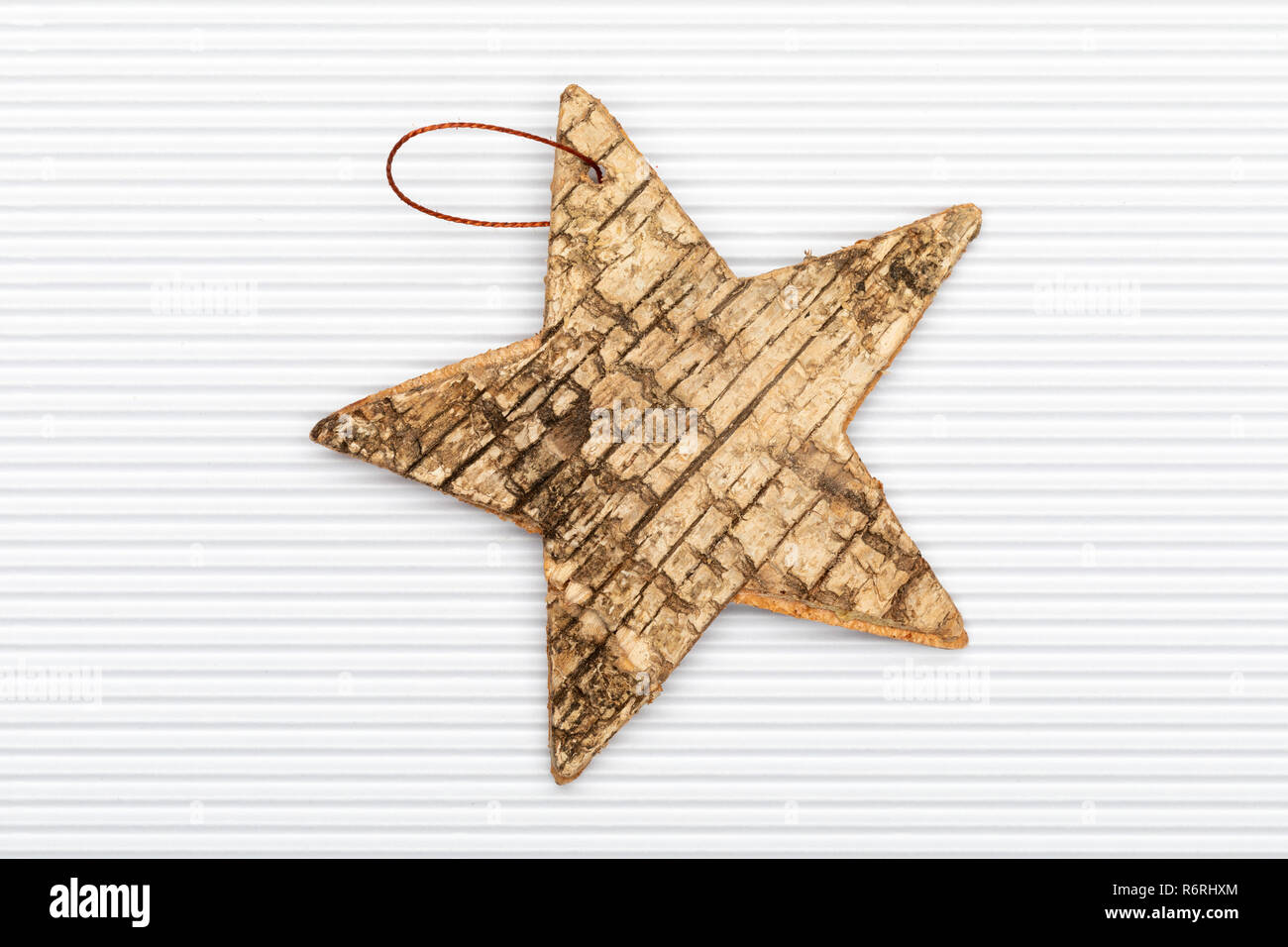 Beautiful star of birch bark on white corrugated cardboard background ...