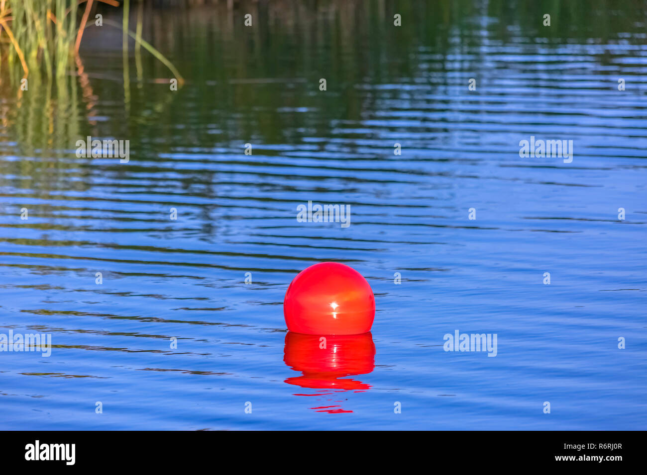 Red ball floating on Oquirrh Lake in Daybreak Utah Stock Photo - Alamy