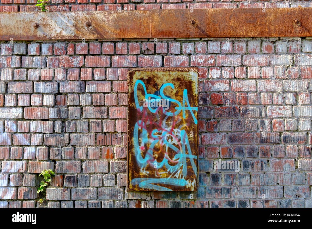 blue graffiti on rusty iron box in weathered brick wall Stock Photo - Alamy