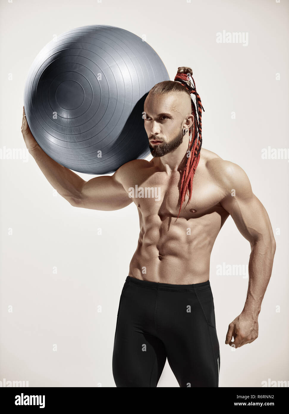 Muscular man holding fitness ball, standing isolated on white Stock ...