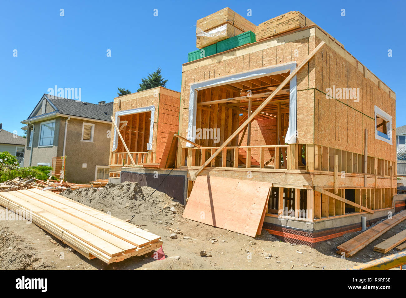New family home under construction with stacks of 2x4 timber boards on ...