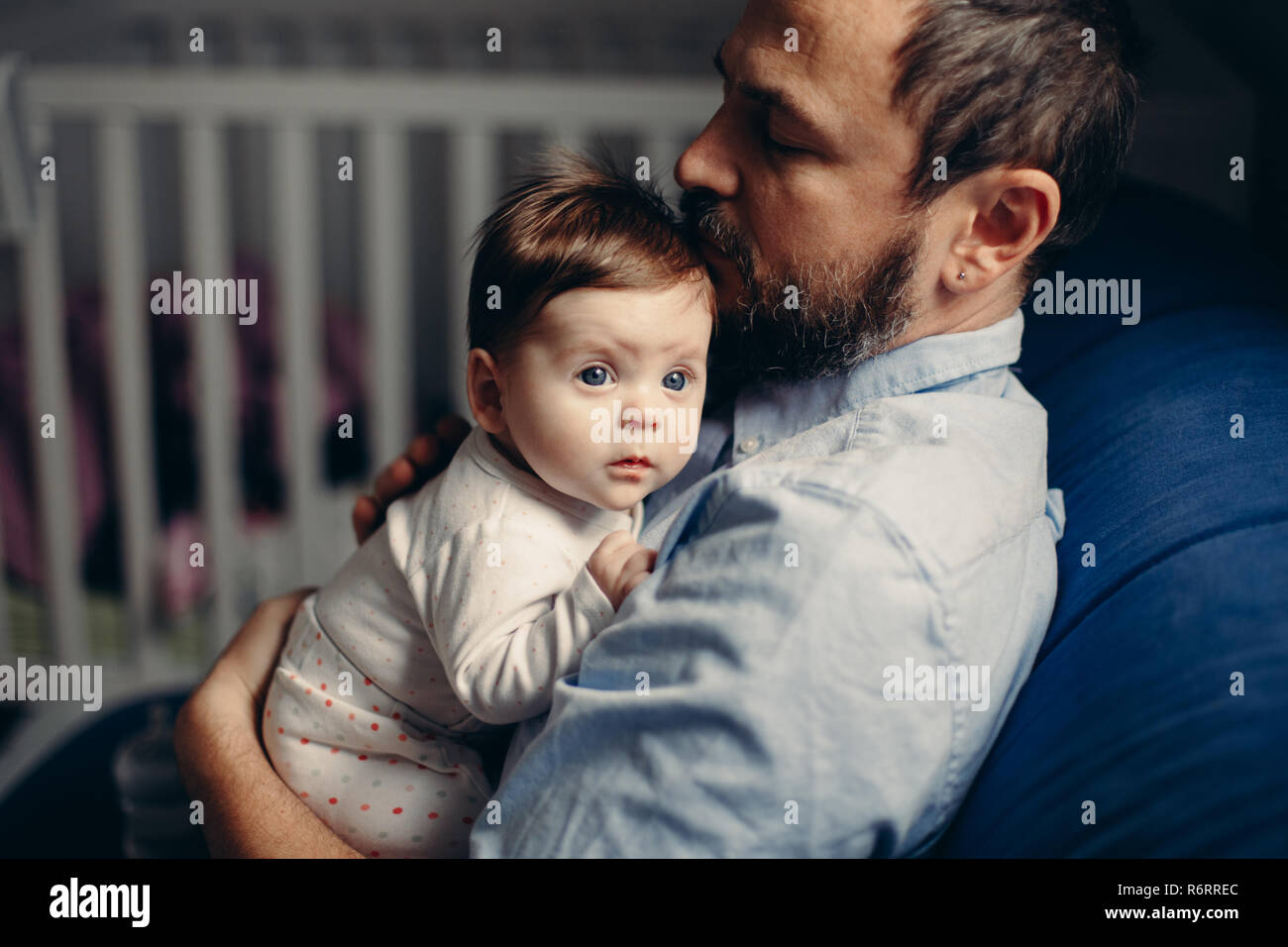 Portrait of middle age Caucasian father hugging and kissing newborn ...
